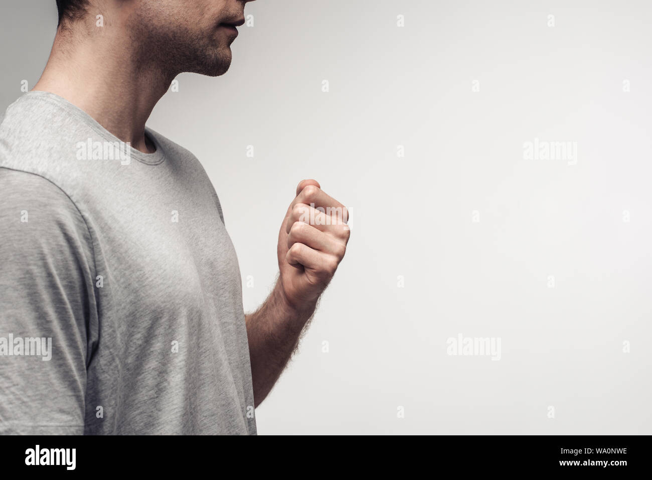 partial view of man holding fist while using body language isolated on ...