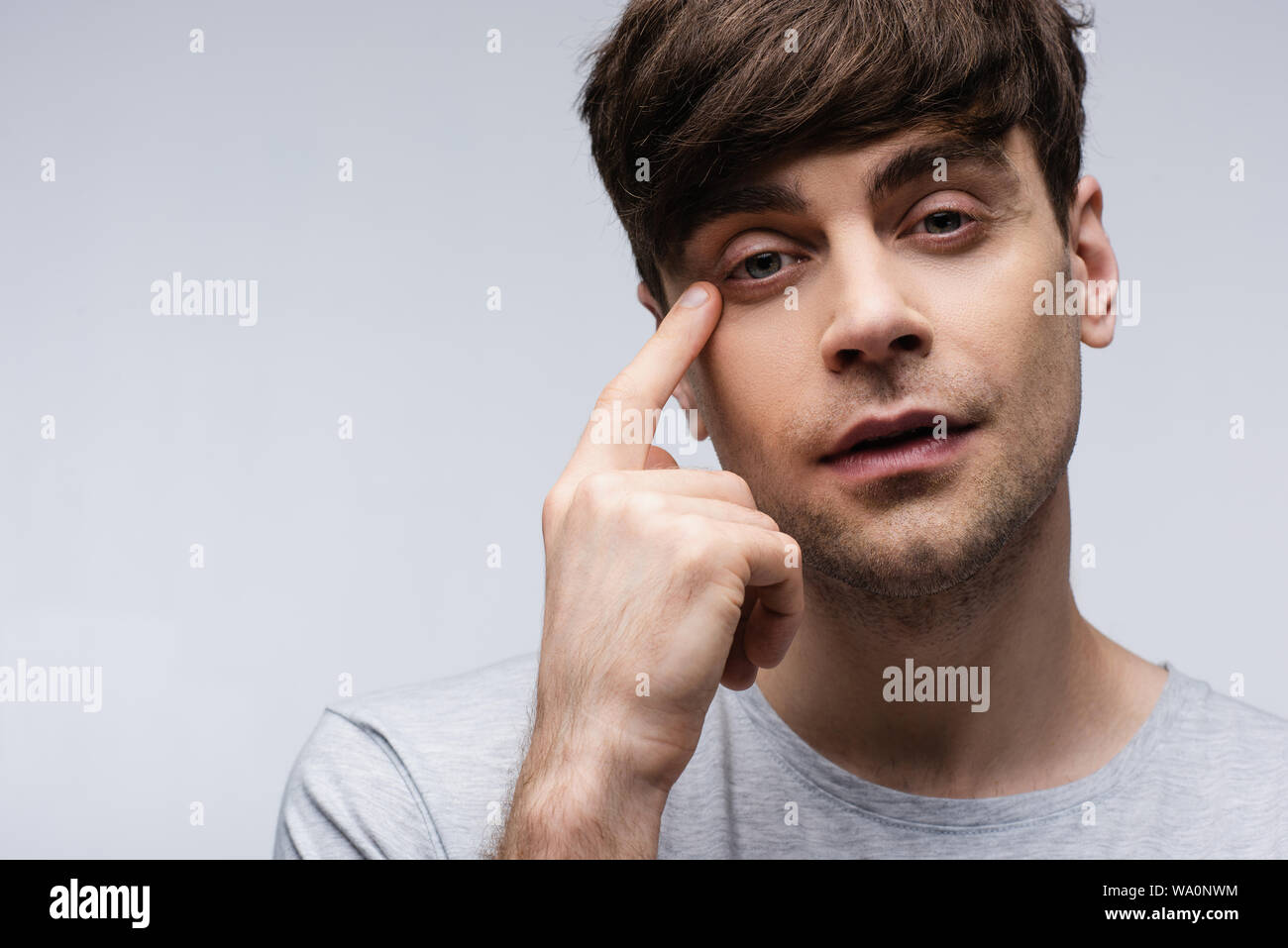 blind man pointing with finger at eye isolated on grey, human emotion ...