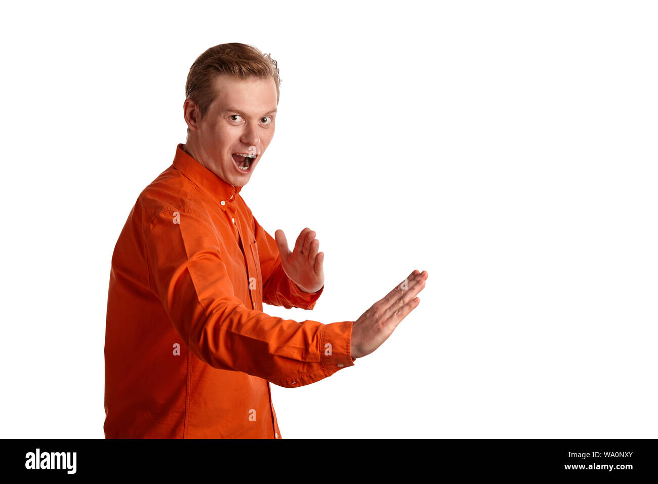 Close-up portrait of a young nice ginger guy in a stylish orange shirt ...