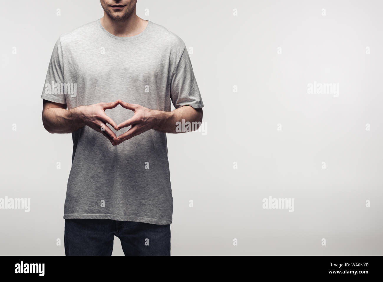 partial view of man in grey t-shirt showing steeple gesture while using ...