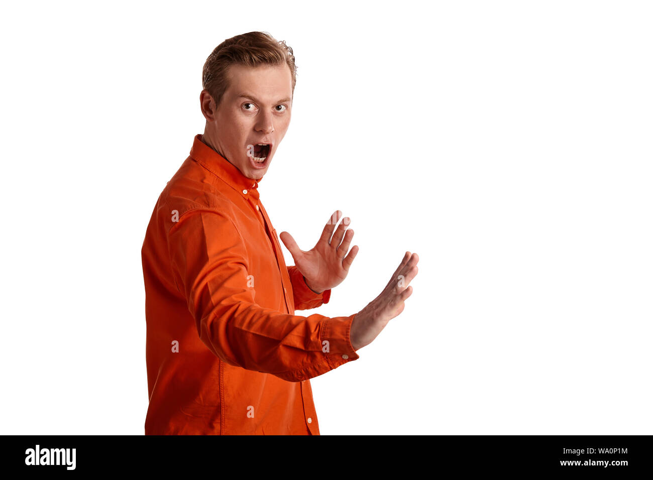 Close-up portrait of a young nice ginger man in a stylish orange shirt ...