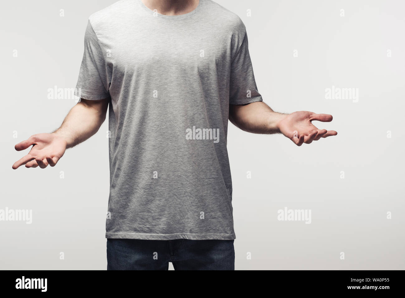 partial view of man in grey shirt showing shrug gesture isolated on ...
