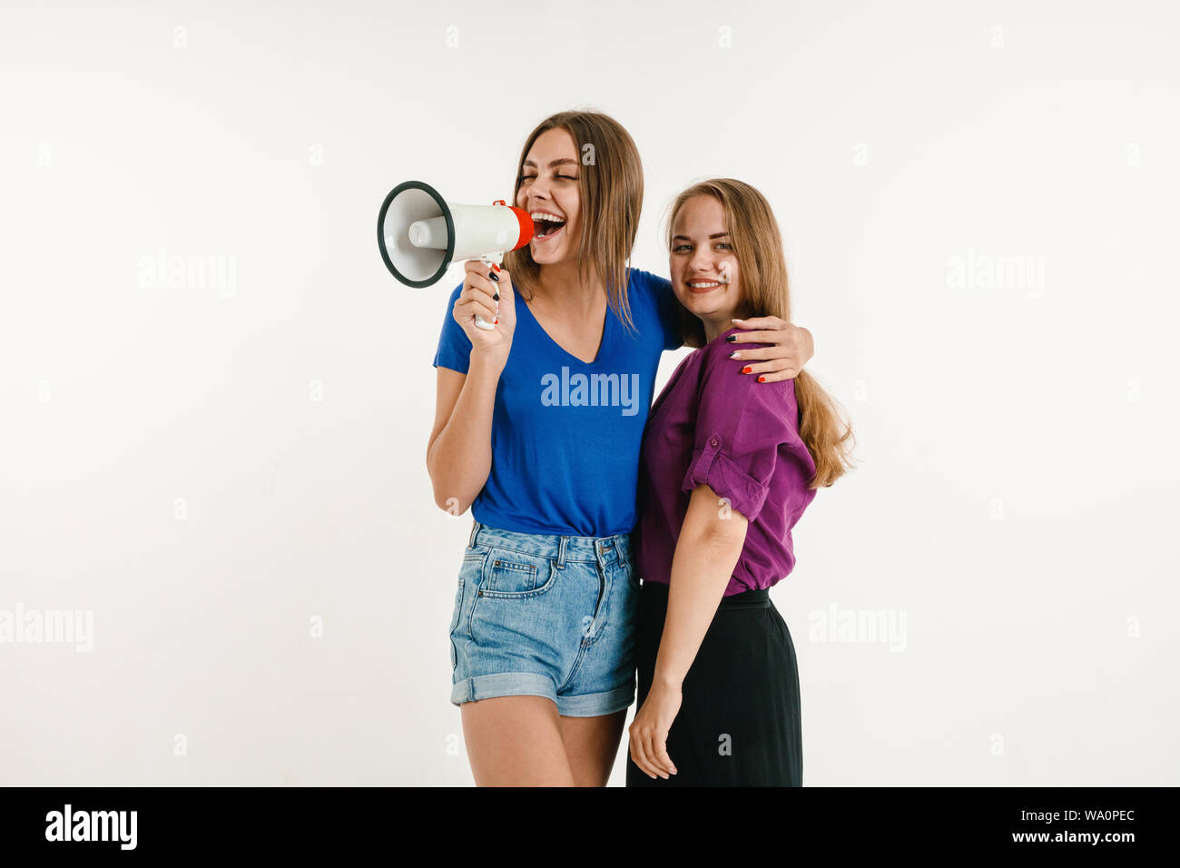 Young women weared in LGBT flag colors on white background. Caucasian ...