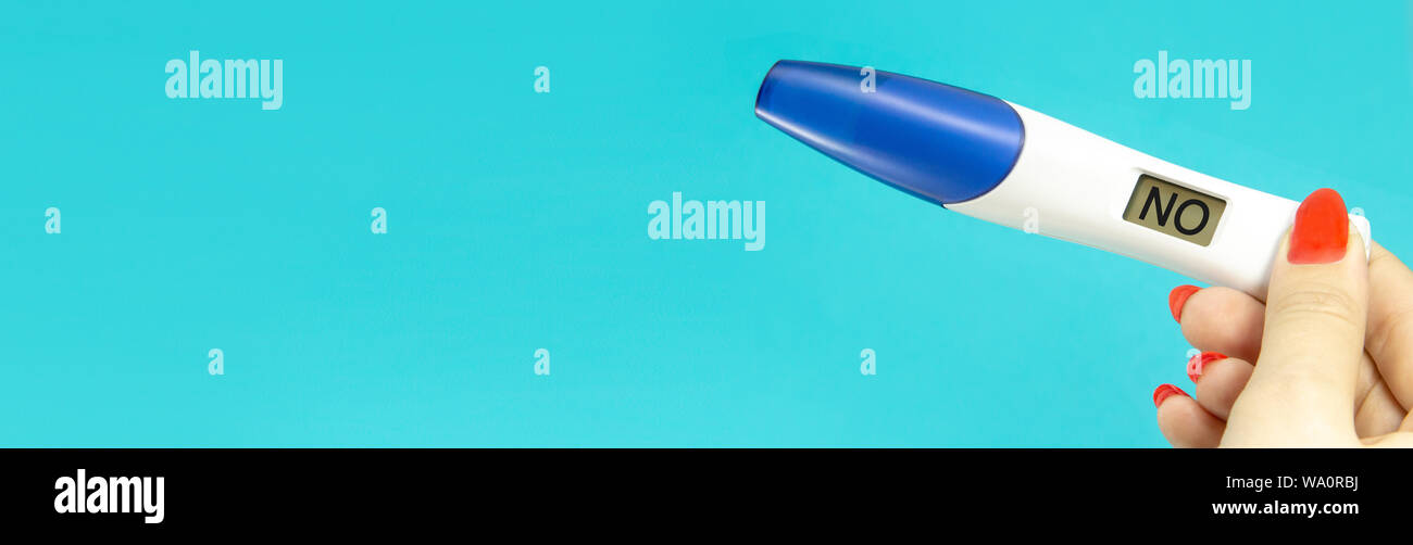 Woman hand holding digital pregnancy test isolated on blue background ...