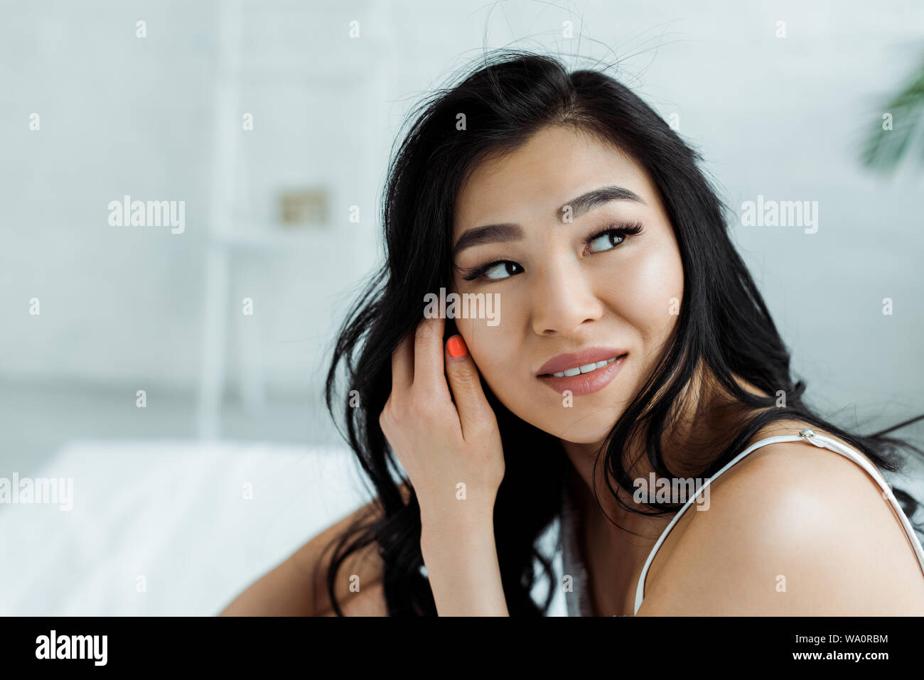 happy thai woman touching hair and smiling at home Stock Photo - Alamy