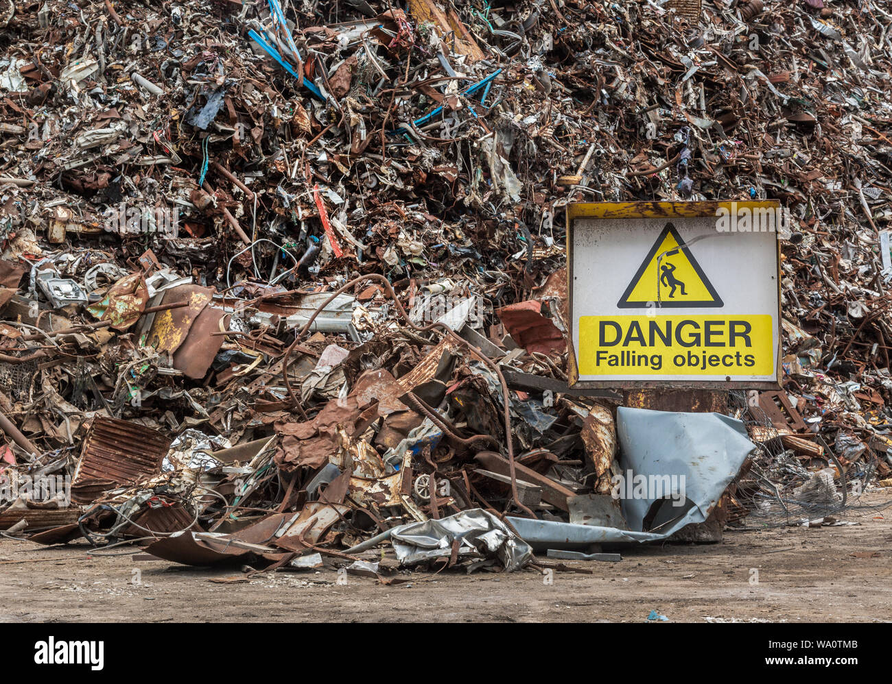 A yellow danger sign in front of a huge heap of scrap metal Stock Photo ...