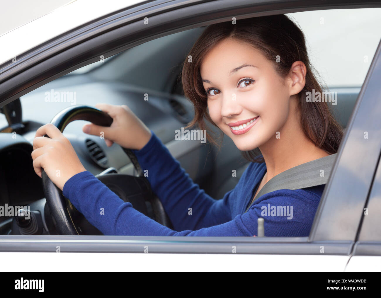 Happy owner of a new car. Pretty woman driver smiling to you from her ...
