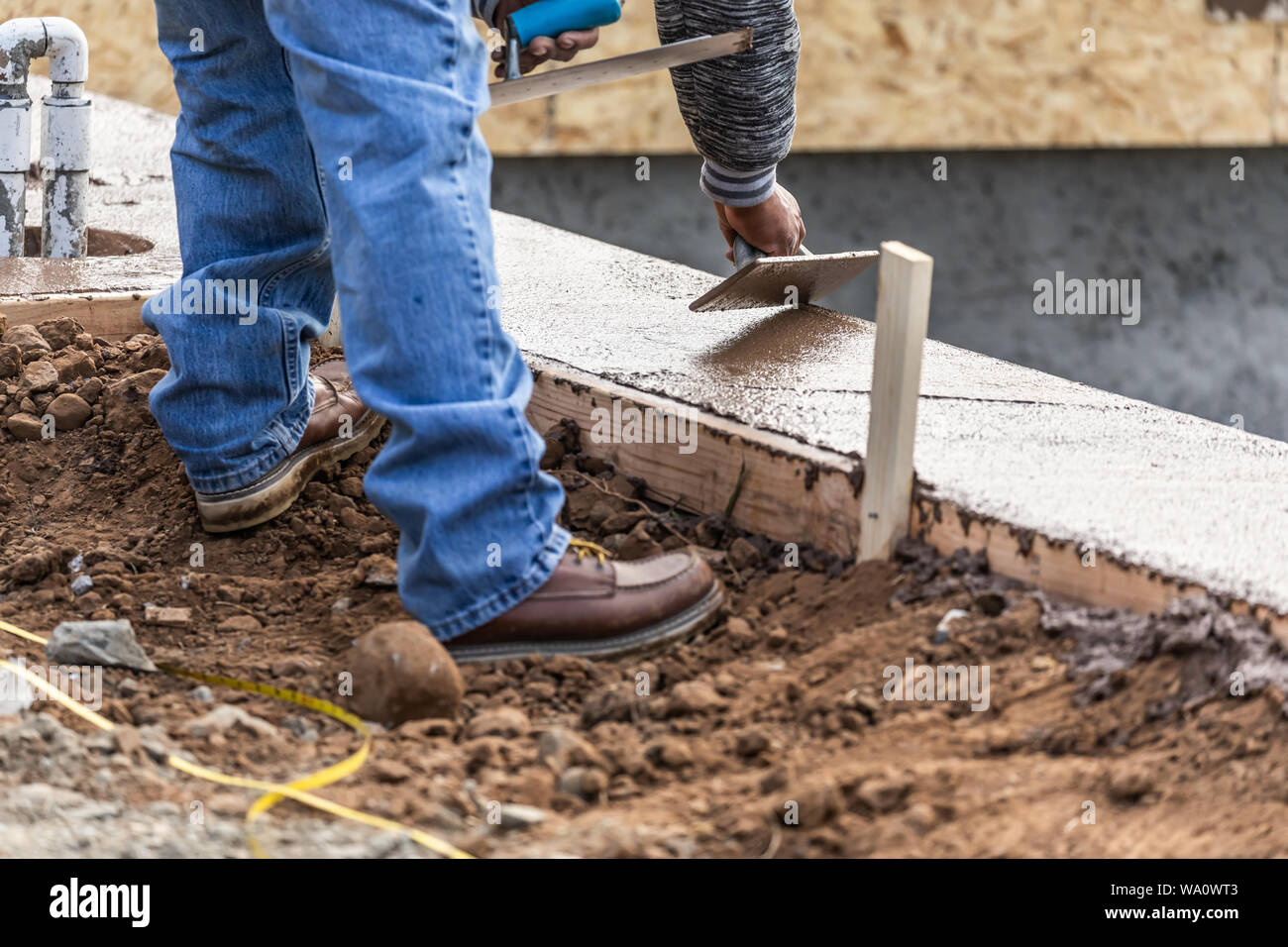 Construction Worker Using Wood Trowel On Wet Cement Forming Coping ...
