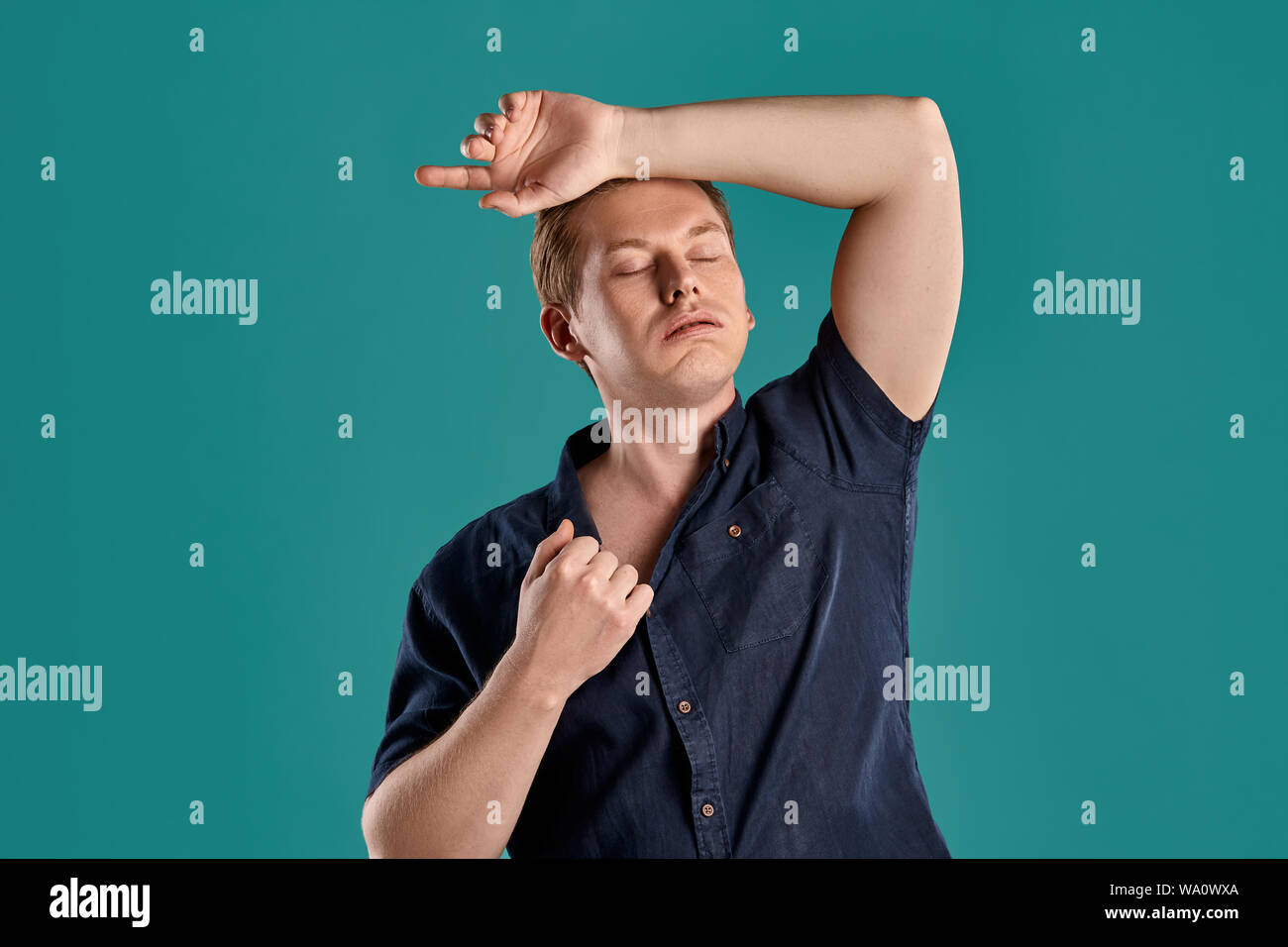 Close-up portrait of a young smart ginger fellow in a stylish navy t ...