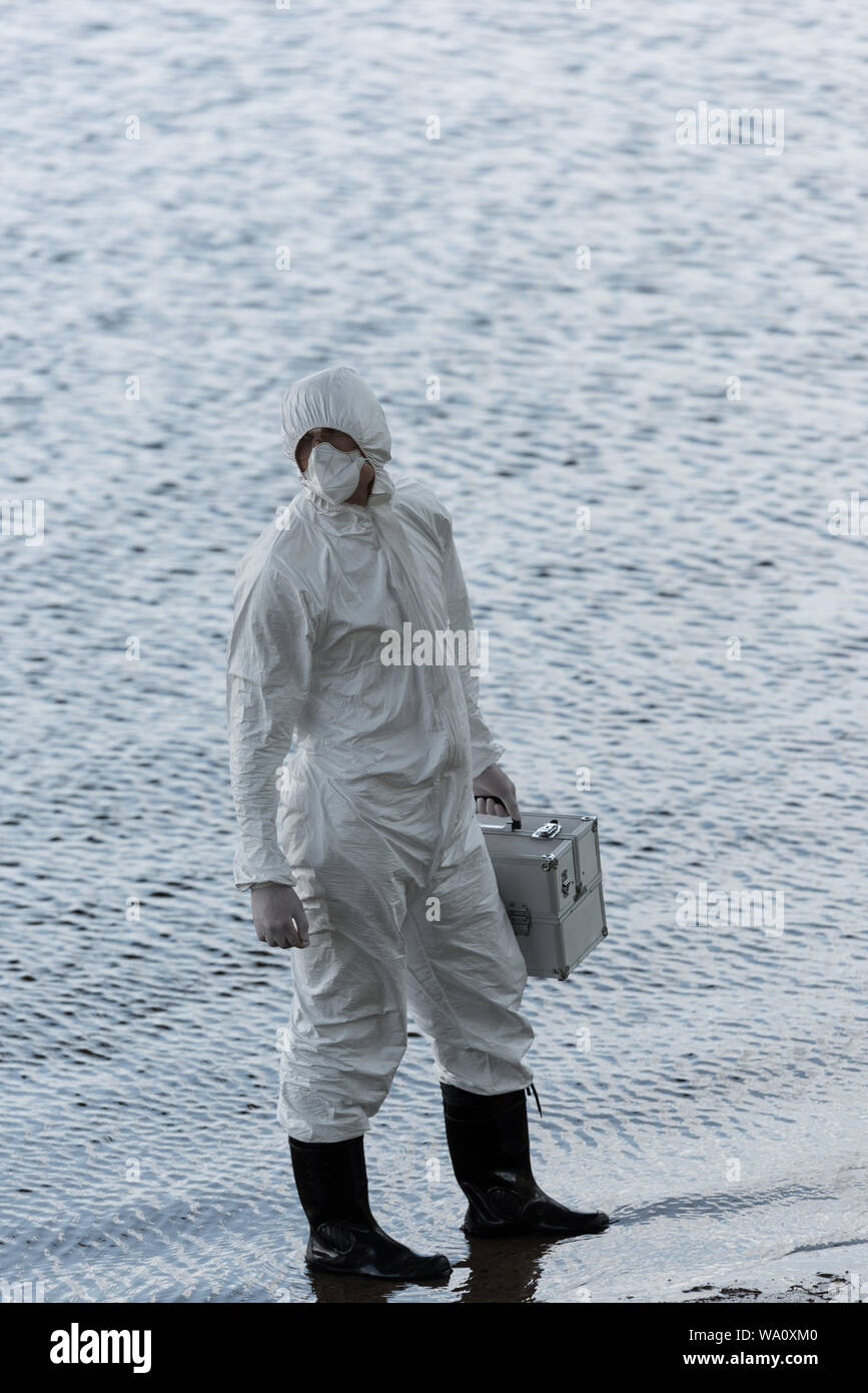 full length view of water inspector in protective costume holding ...