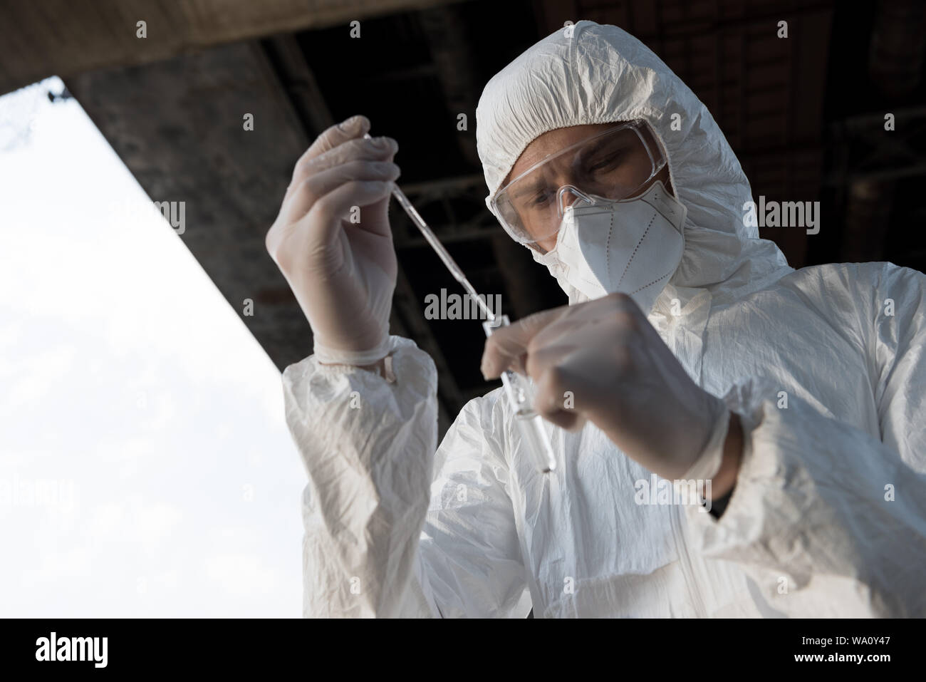 selective focus of water inspector in protective costume, respirator ...