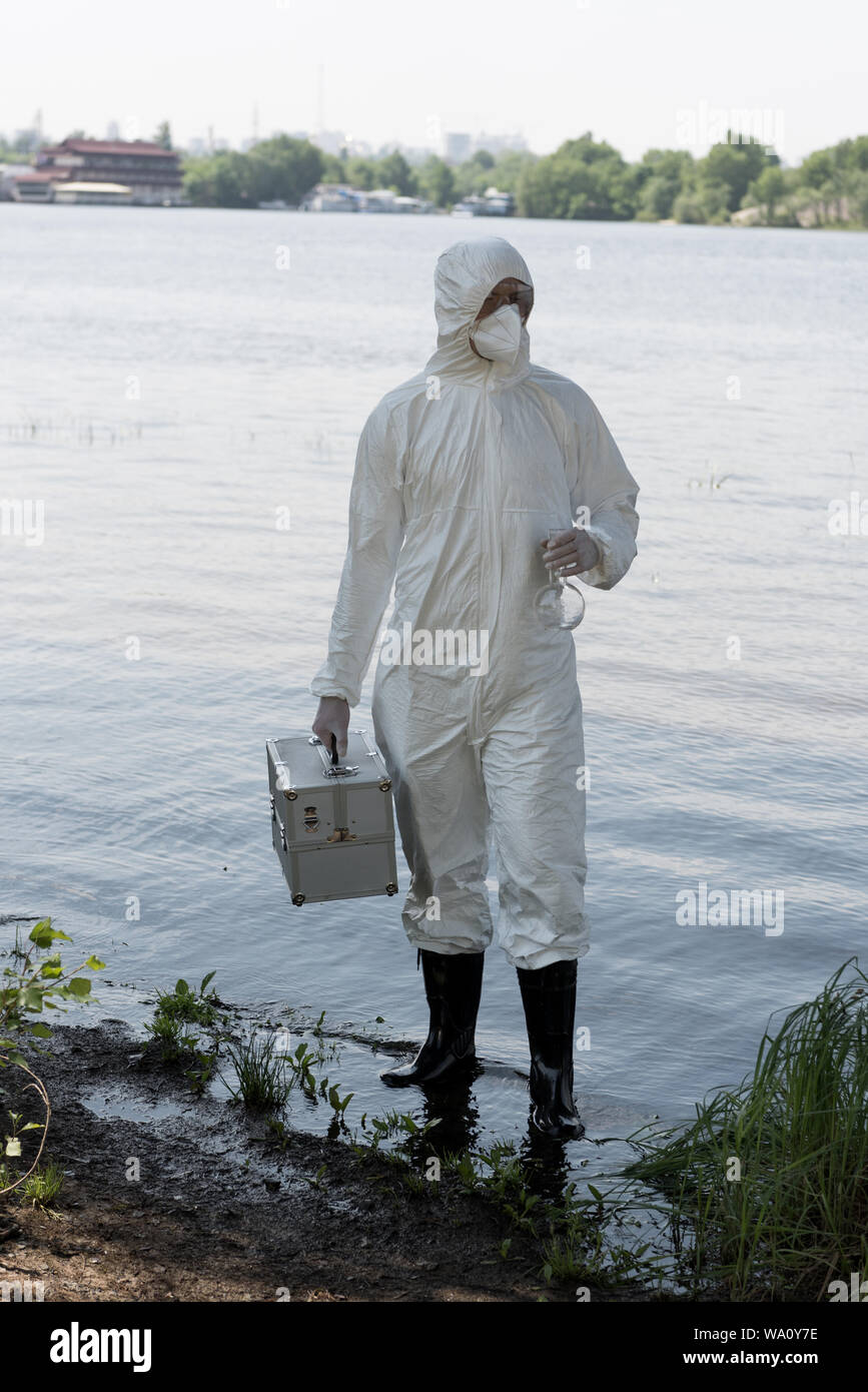 full length view of water inspector in protective costume holding ...