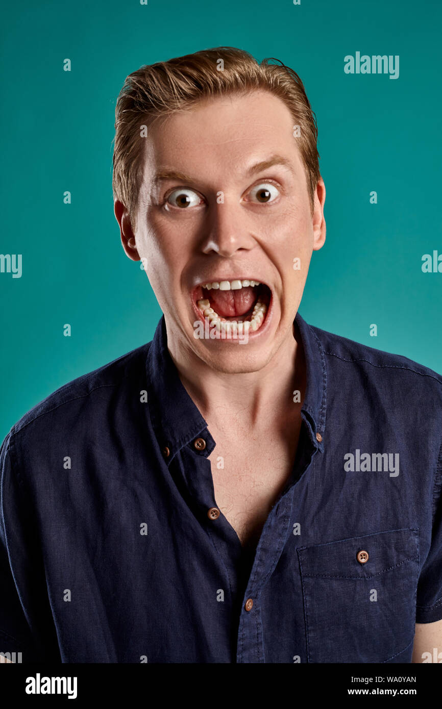 Close-up portrait of a young nice ginger man in a stylish navy t-shirt ...