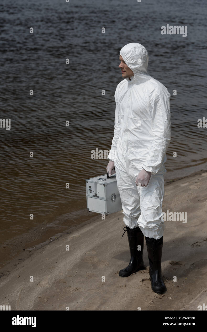 full length view of water inspector in protective suit holding ...