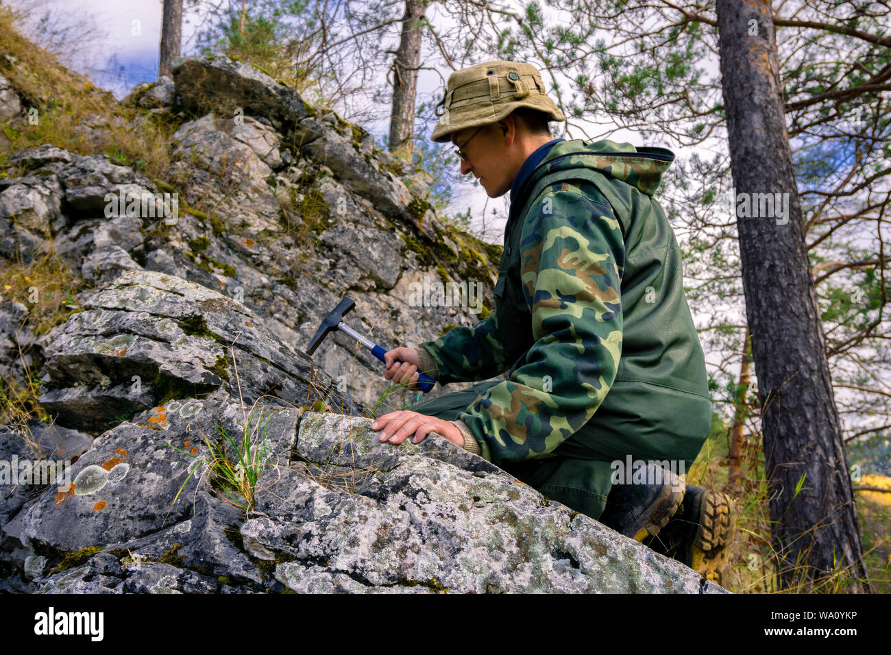 geologist using a geological hammer takes a rock sample outdoor Stock ...