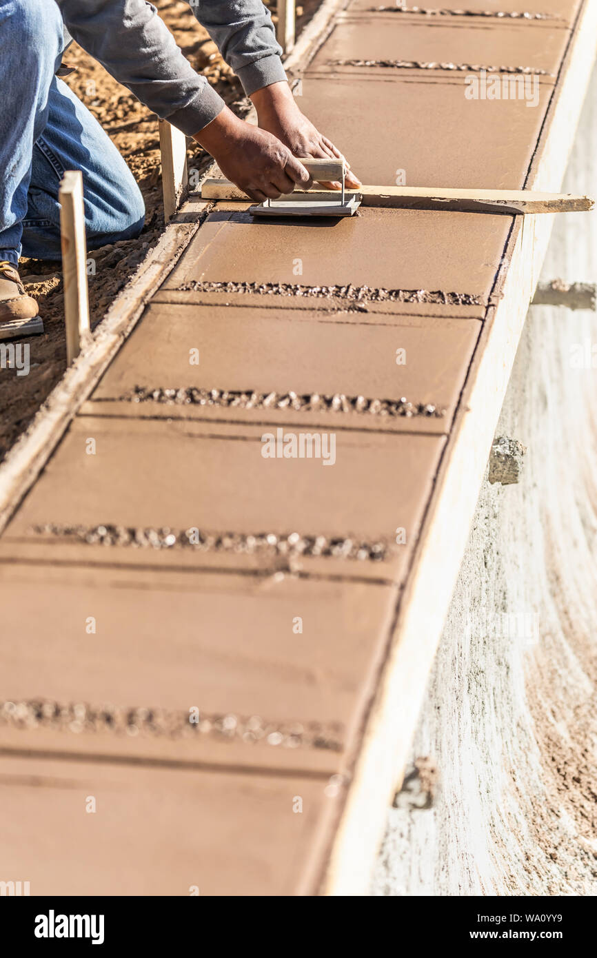 Construction Worker Using Hand Groover On Wet Cement Forming Coping ...