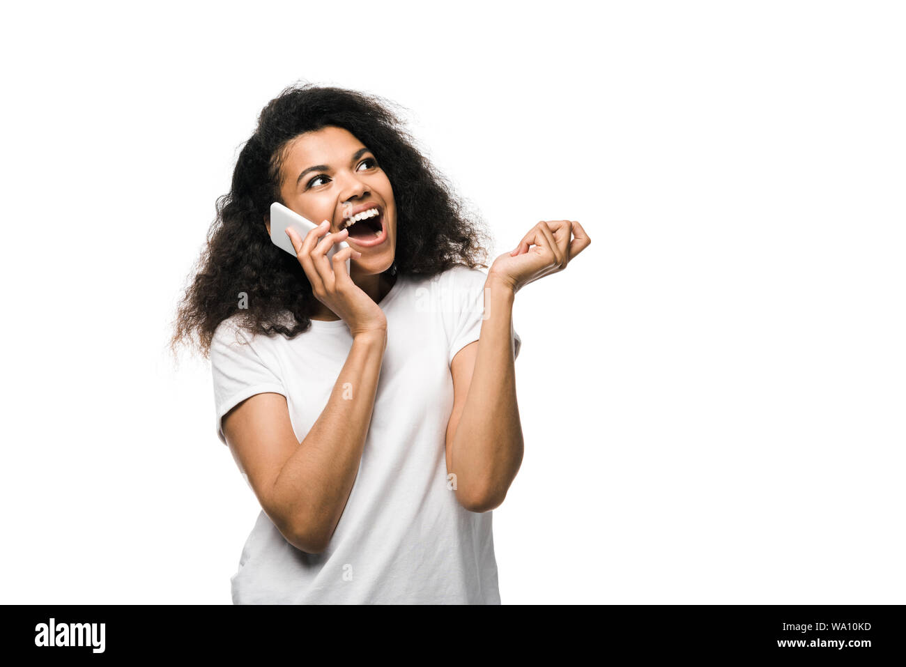 excited african american girl talking on smartphone and gesturing ...