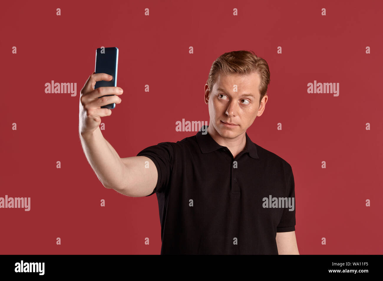 Close-up portrait of a young elegant ginger person in a stylish black t ...