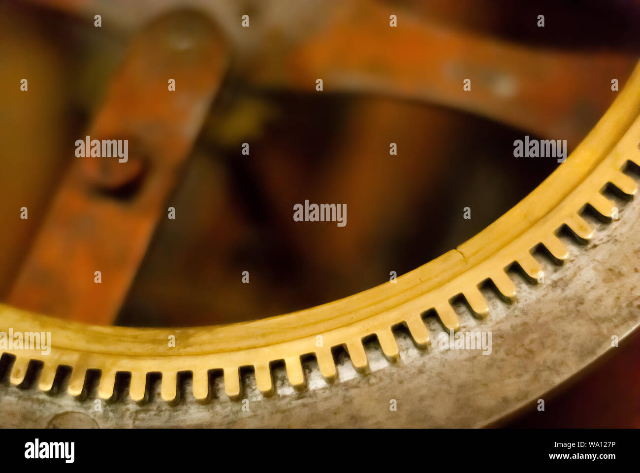 blurred background - a fragment of a clock mechanism with a gear wheel ...