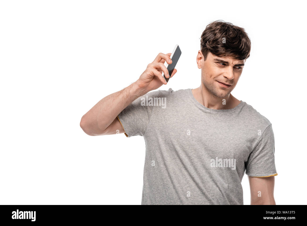 positive young looking away while talking on smartphone isolated on ...