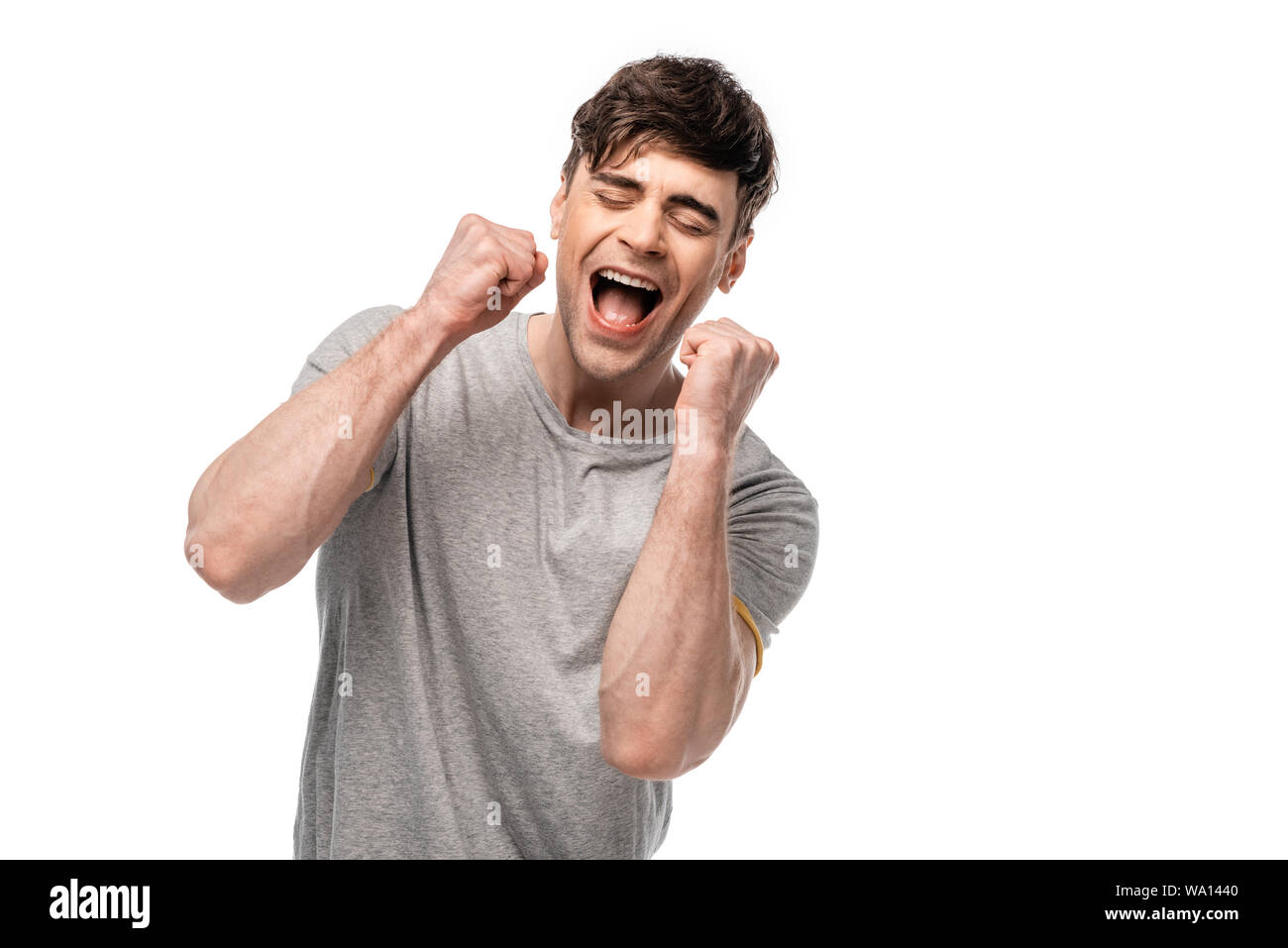 excited young man showing winner gesture with closed eyes isolated on ...