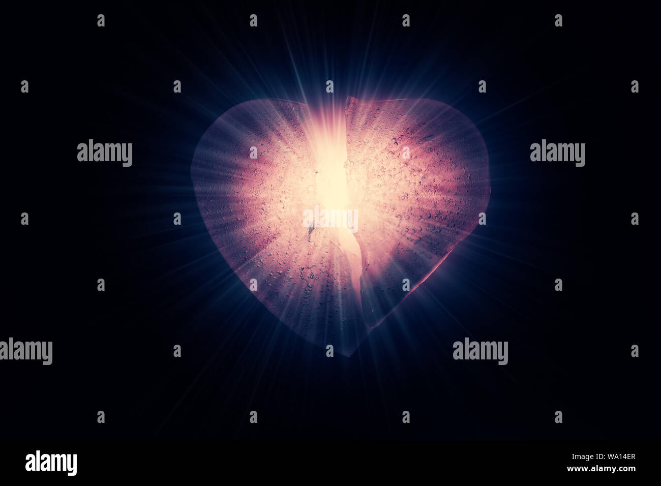 Ice frozen broken in half heart symbol of a bright red color close-up ...