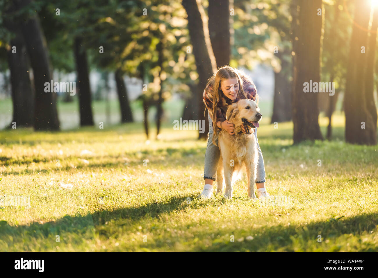 full length view of beautiful girl in casual clothes hugging golden ... full length view of beautiful girl in casual clothes hugging golden ...