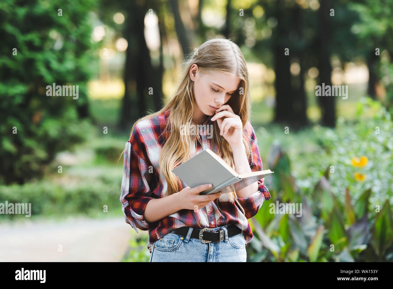 focused young girl in casual clothes reading book Stock Photo - Alamy