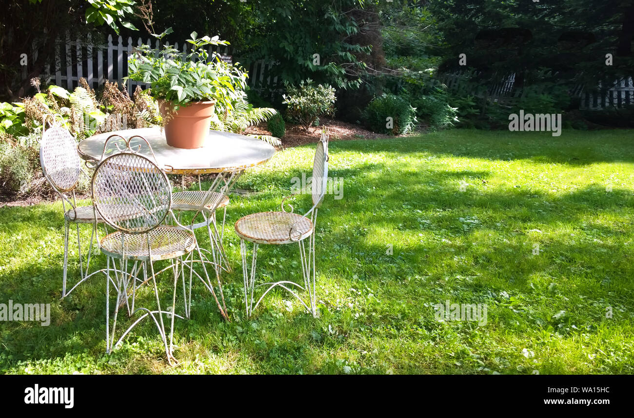 Old fashioned outdoor furniture in a pretty backyard Stock Photo - Alamy