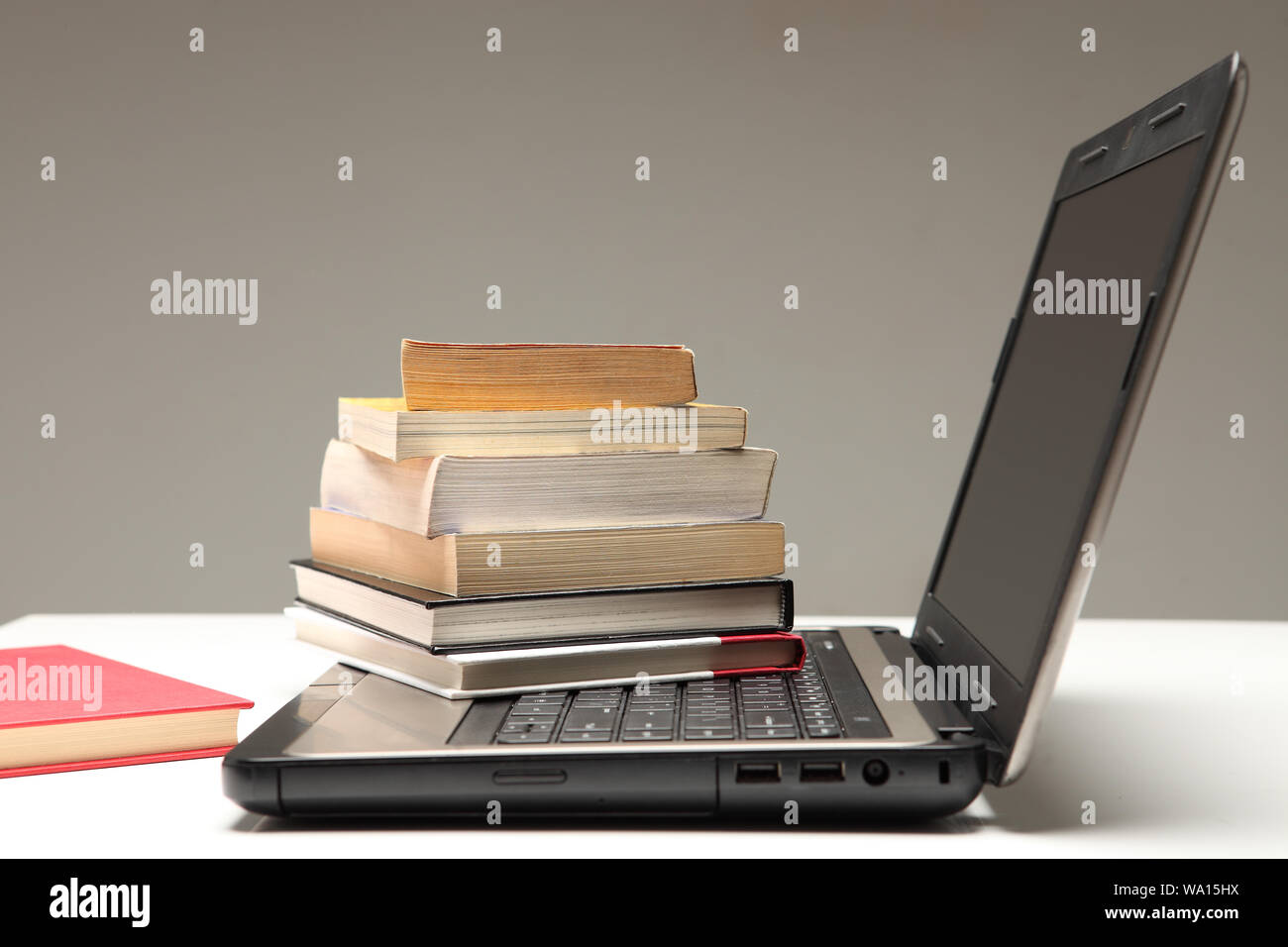 Laptop with a stack of books Stock Photo - Alamy