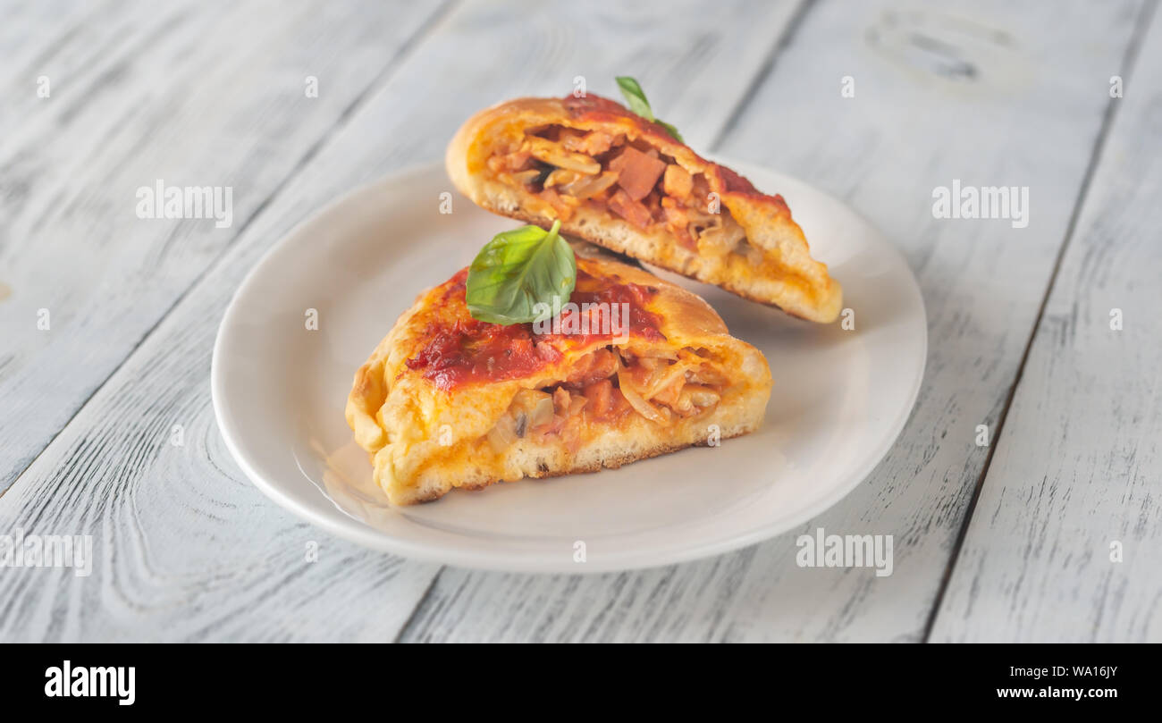 Homemade calzone stuffed with pancetta and mushrooms: cross section ...