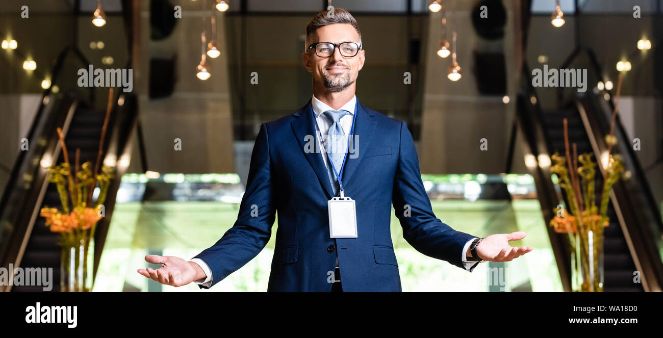 panoramic shot of handsome businessman in suit and glasses with ...