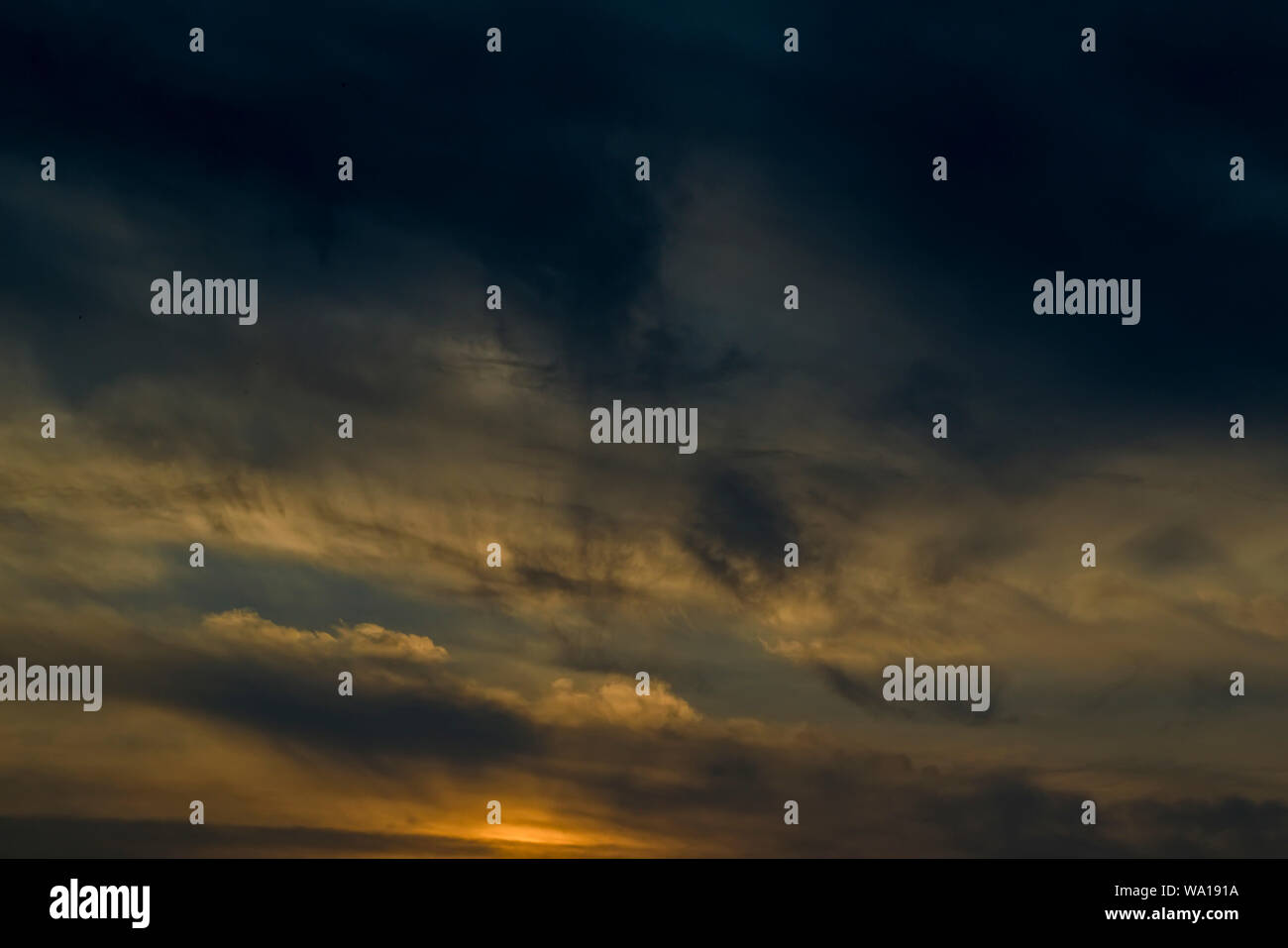 Cumulus sunset clouds with sun setting down. The sky with dark clouds ...