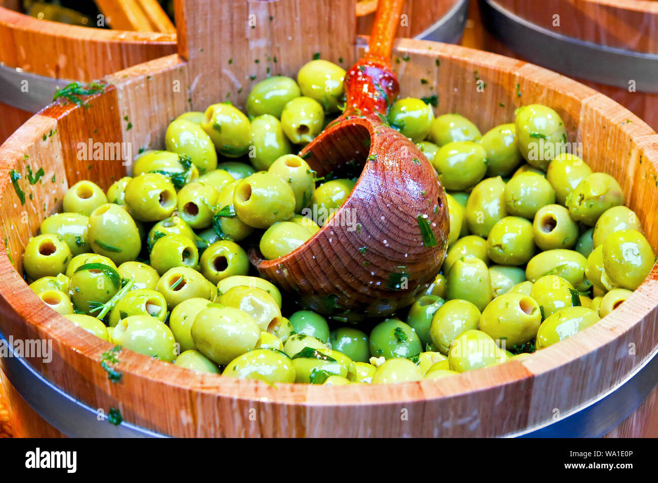 Green olives with herbs in wooden bucket Stock Photo - Alamy