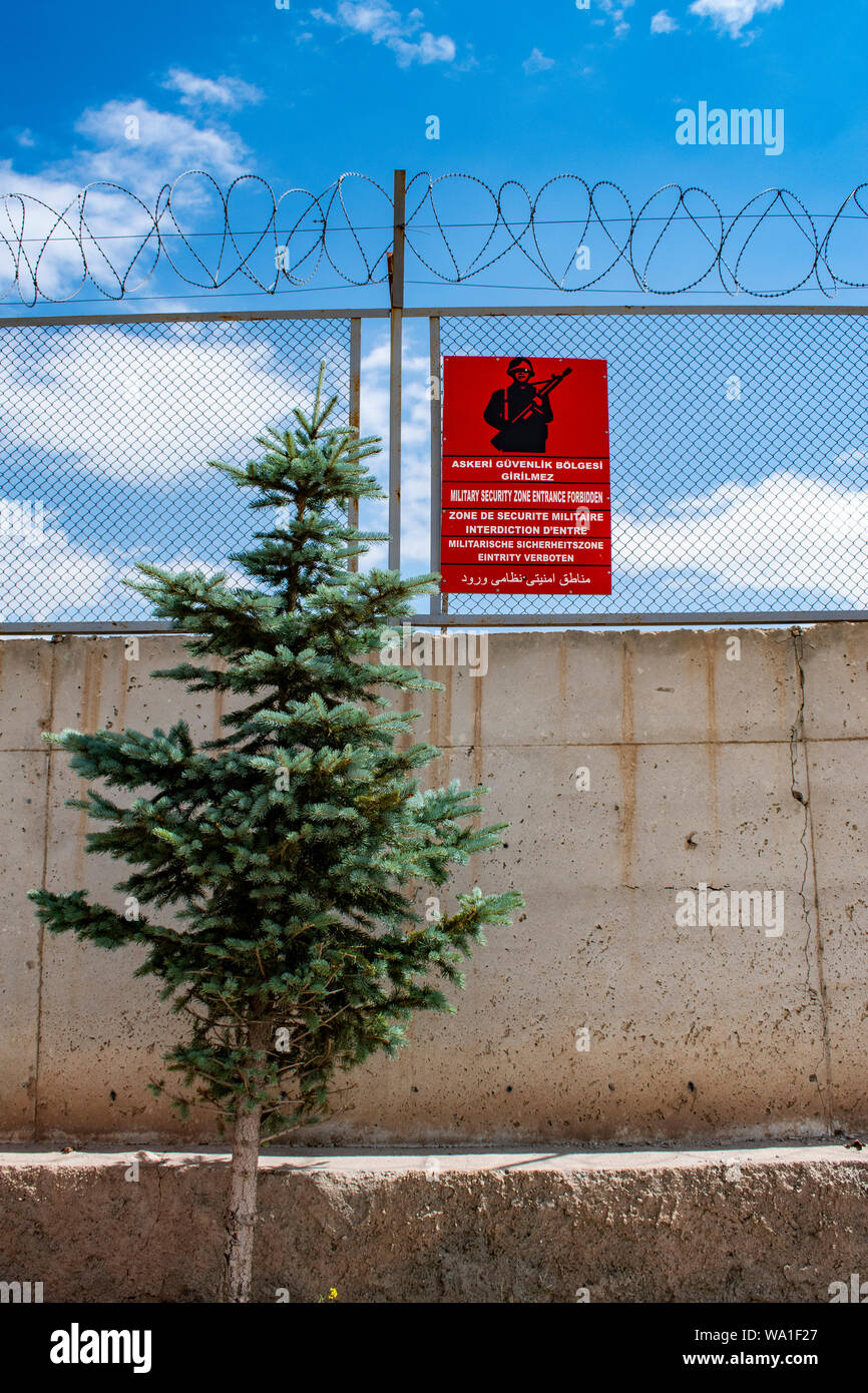 Dogubayazıt, Turkey: fence with barbed wire and red sign of military ...