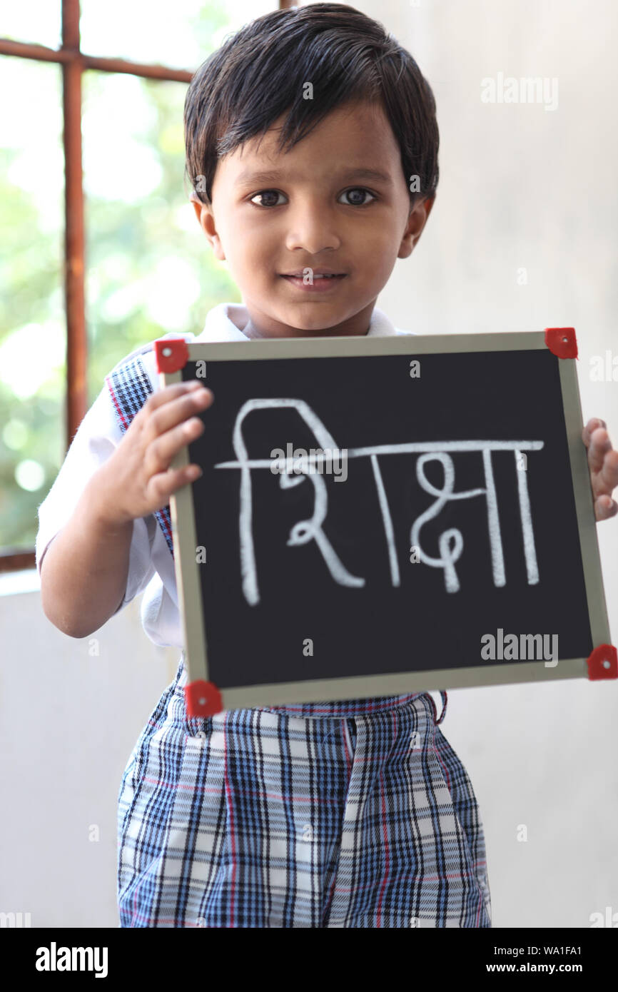 Schoolboy holding a slate "Shiksha" written on it Stock Photo - Alamy