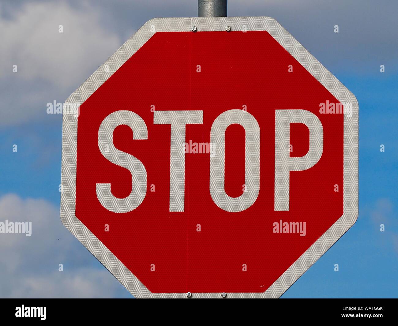 Stop sign in front of blue sky Stock Photo - Alamy