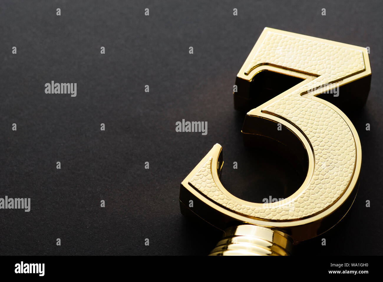 Third placed runner up trophy or award in the shape of a textured ...