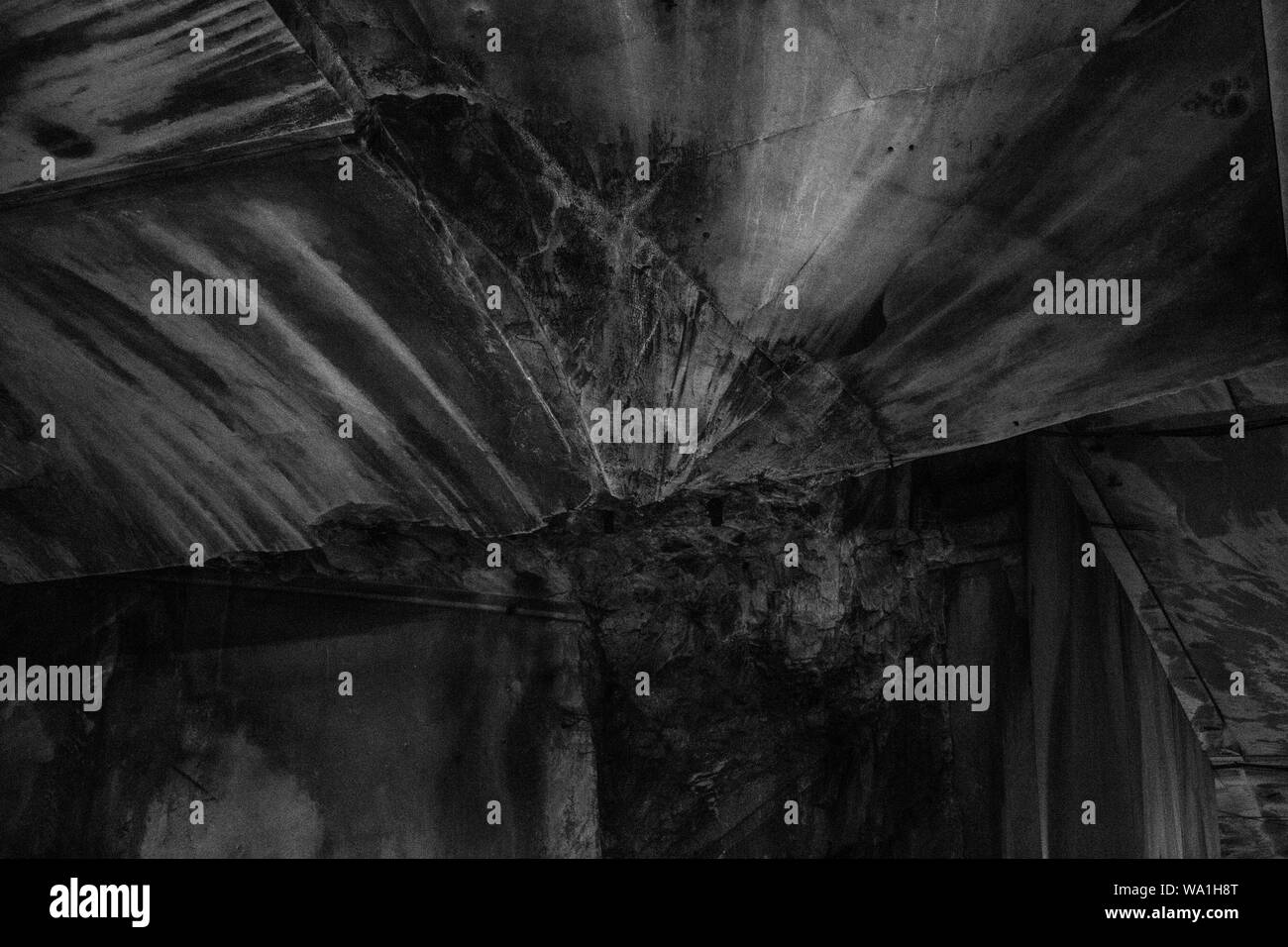 Closeup grayscale shot of an old creepy weathered basement with cracked ...