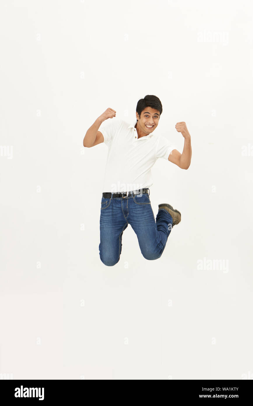 Young man jumping in air and smiling Stock Photo - Alamy