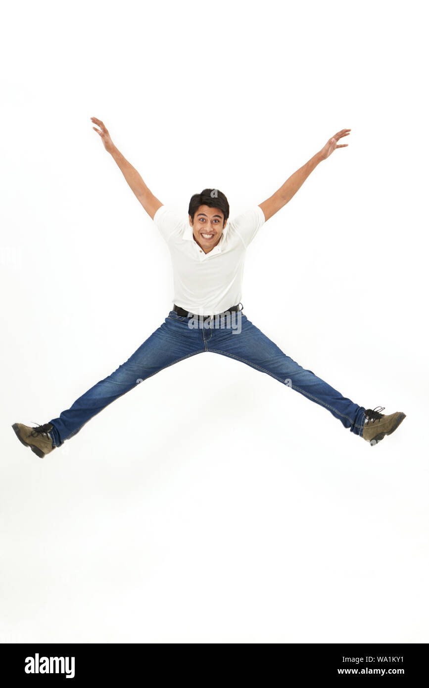 Young man jumping in air and smiling Stock Photo - Alamy