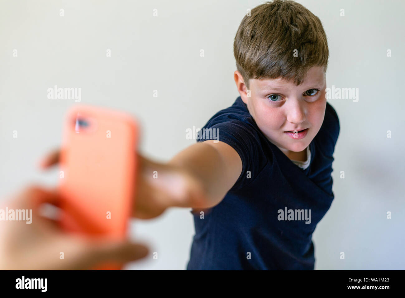 Blond fat kid reaches his hand to the mobile phone. Phone addiction ...