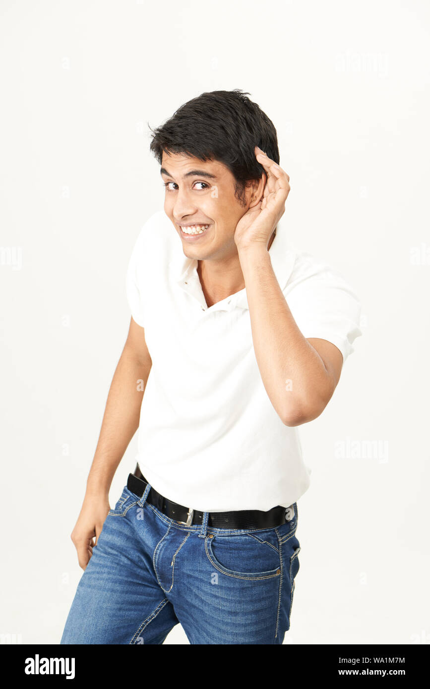 Nosy young man trying to listen carefully someone conversation isolated ...