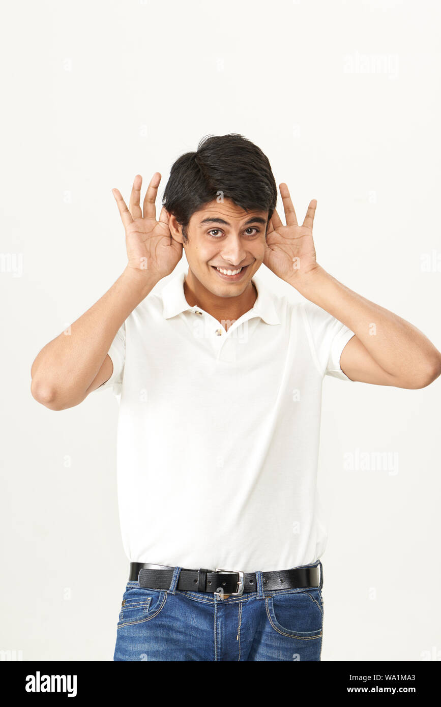 Nosy young man trying to listen carefully someone conversation isolated ...