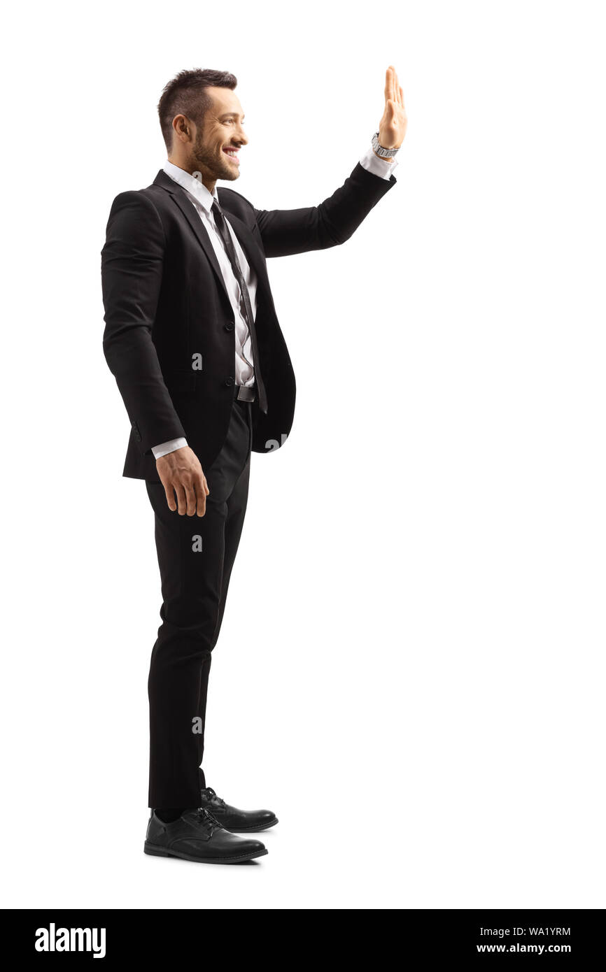 Full length shot of a young man in a suit greeting with hand and ...