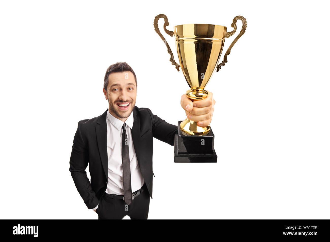 Happy young man in a suit holding a gold trophy cup isolated on white ...