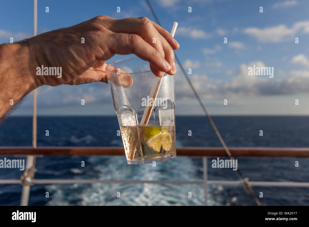 Glass of gin and tonic, with the sea in the background, view from deck ...