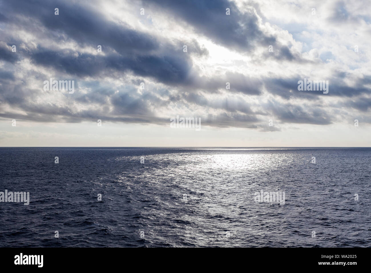 Rays of the sun filtering through the clouds over the sea forming ...