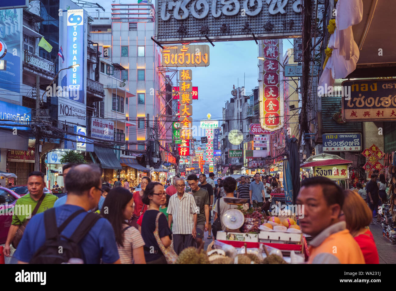Bangkok, Thailand - June 2, 2019: a diverse crowd walks along Yaowarat Road with its Chinese and ...