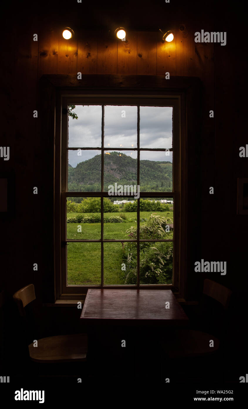 View of mountains and fields through a window in a rustic bistro in ...
